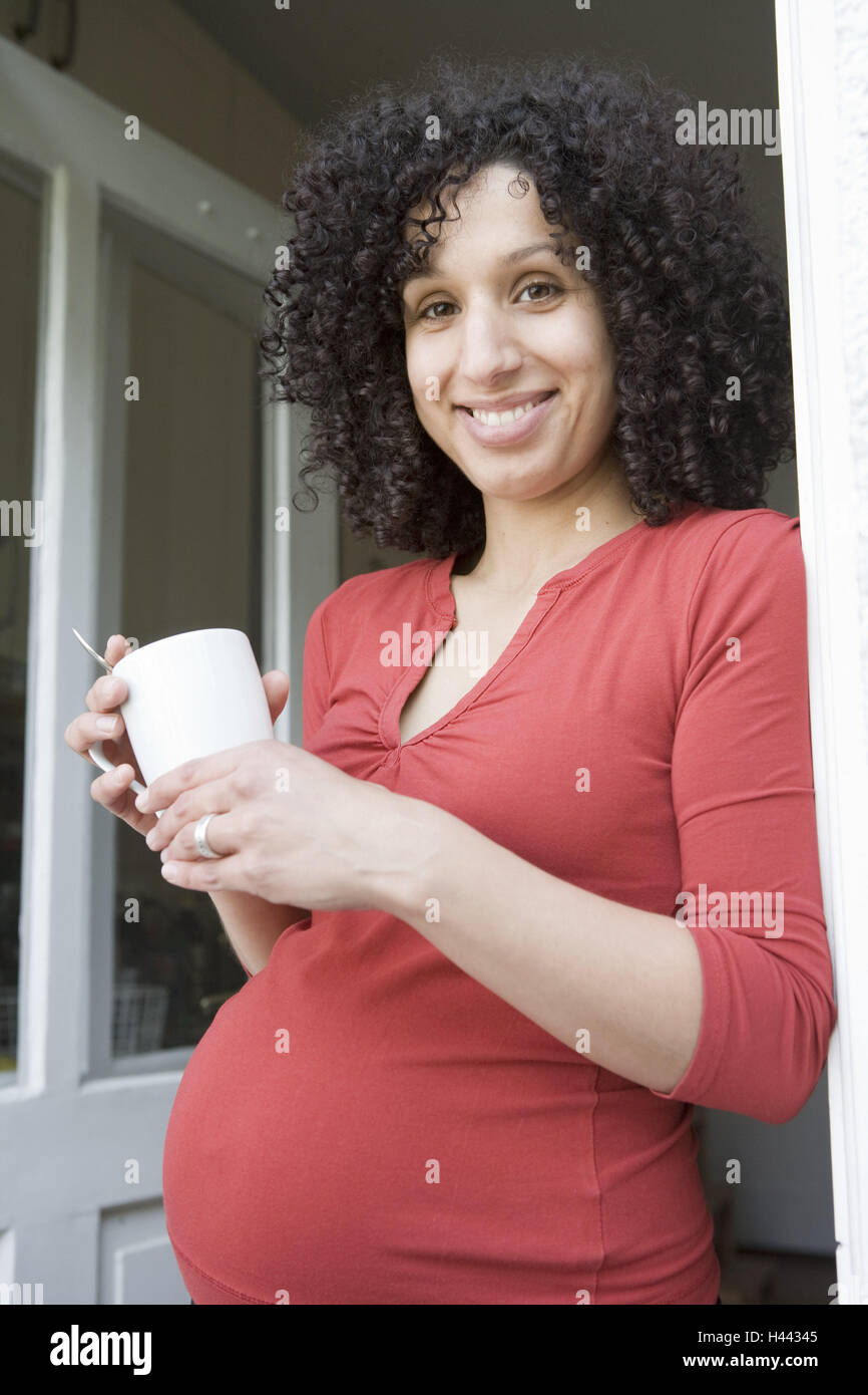 Woman, stand young, pregnant, smile, door frames, cup, hold, model ...