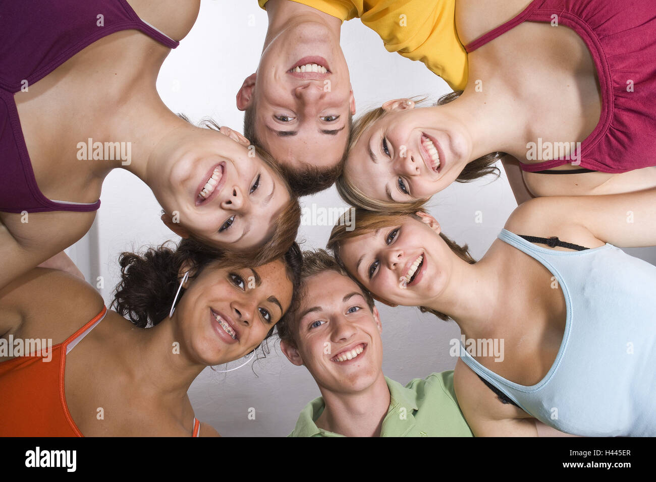 six young people, heads each other, circle, stand, laugh, from below ...