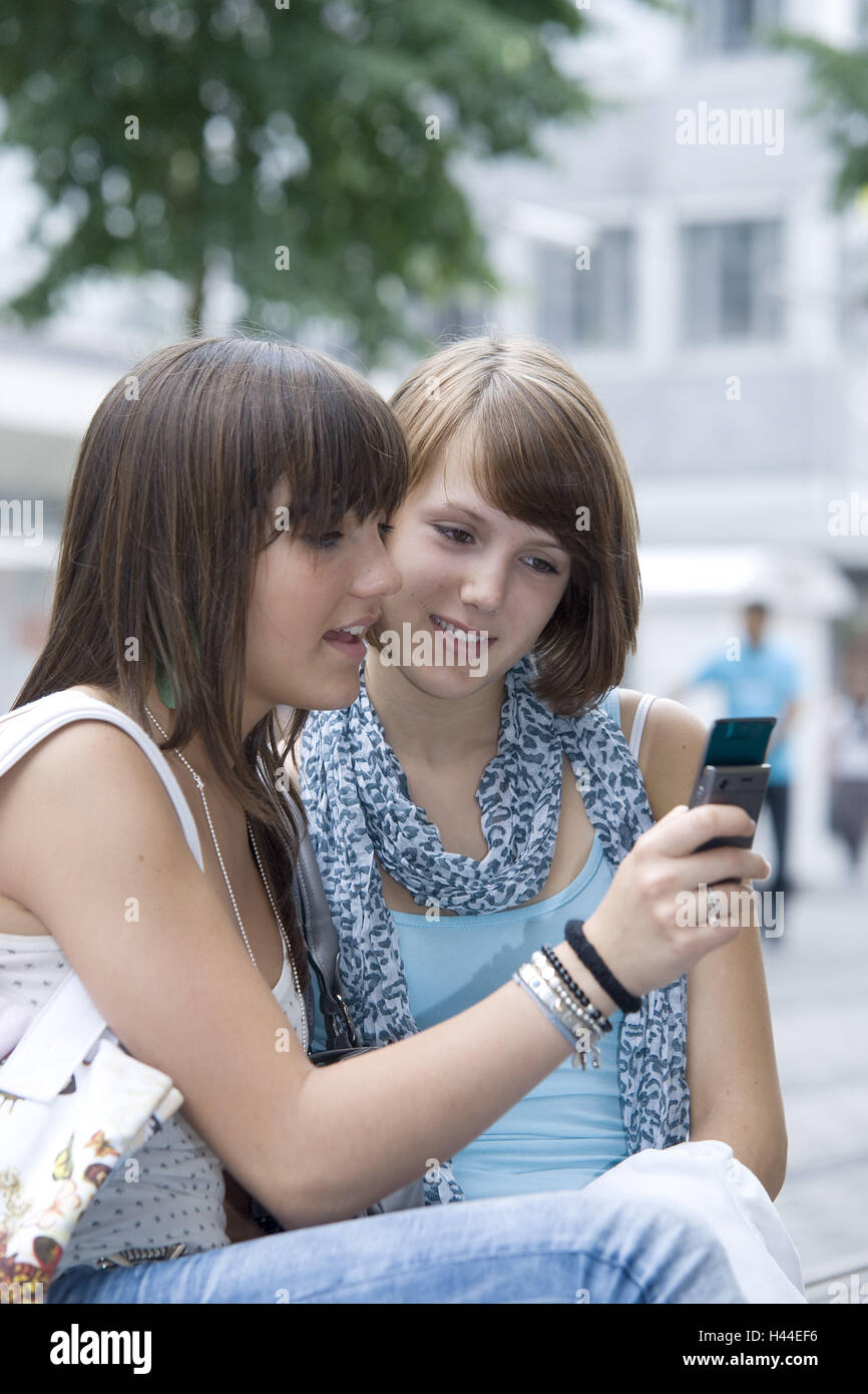 two girls, mobile phone, look, smile, outside Stock Photo - Alamy