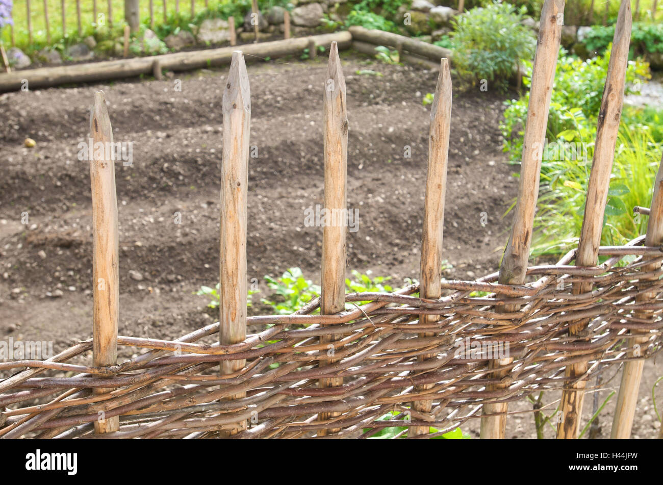 Wooden fence, braided, view in vegetable garden Stock Photo - Alamy