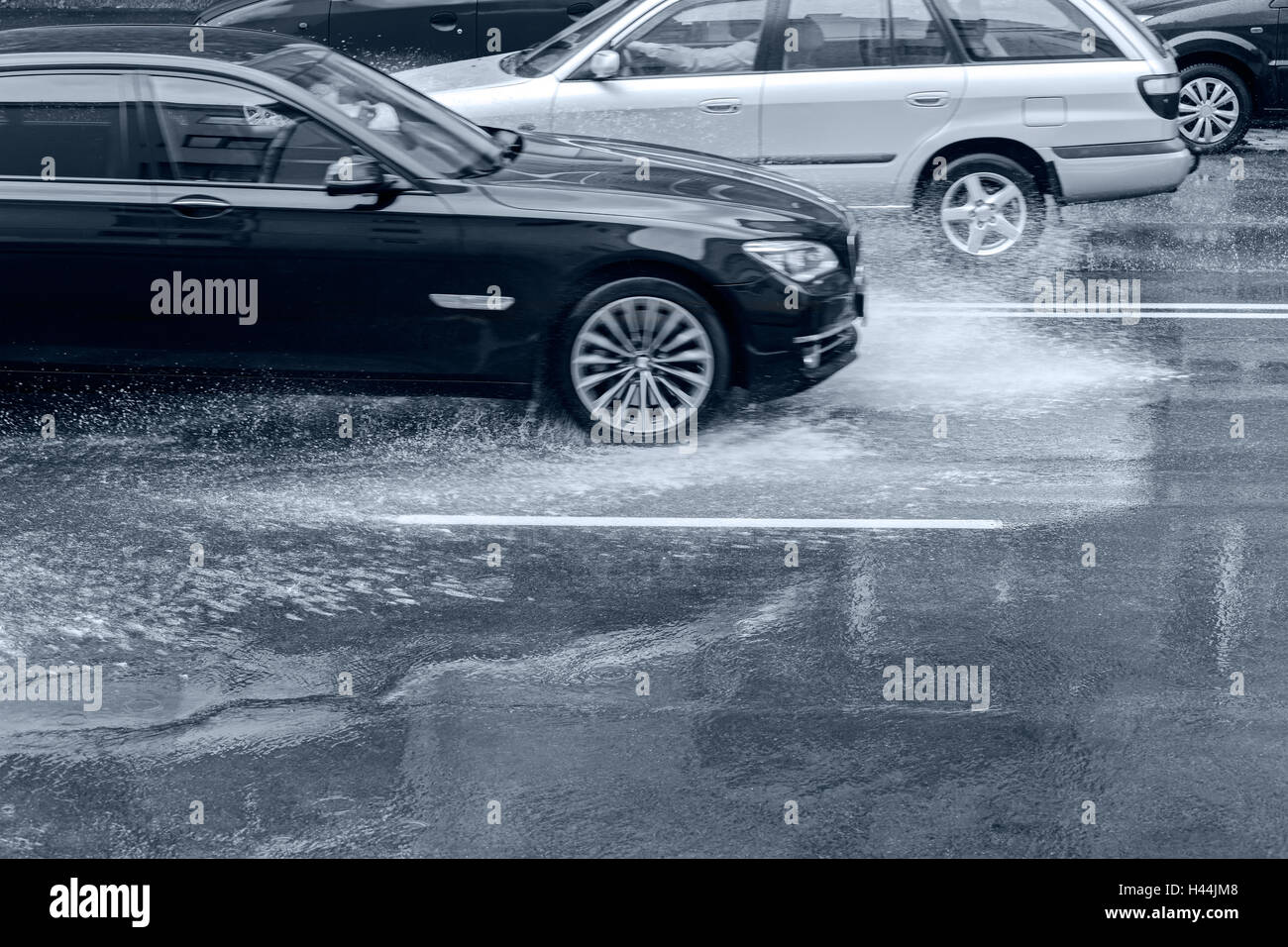car driving on wet road with splashing water after heavy rain Stock ...
