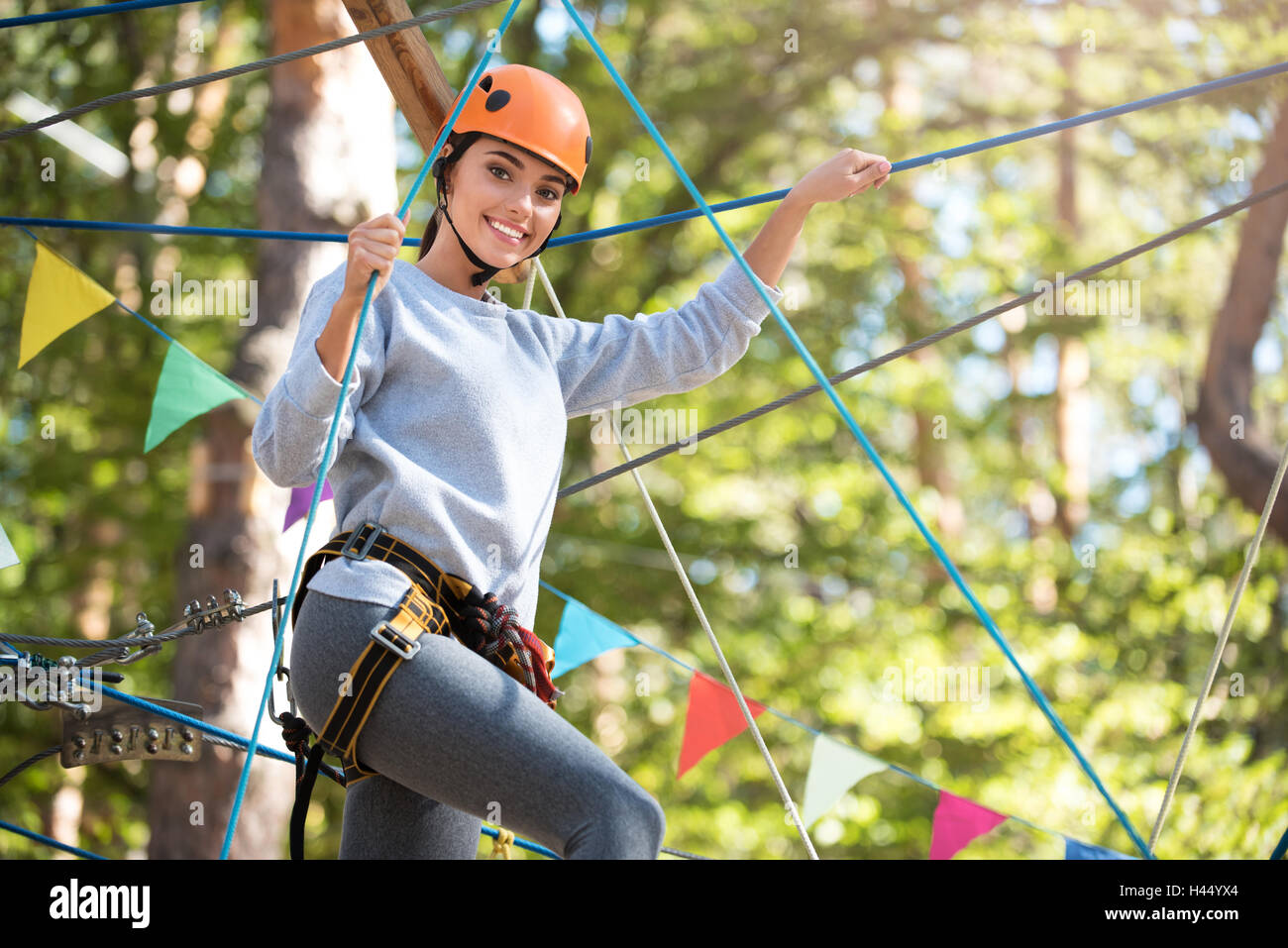 Nice cheerful woman following the rope route Stock Photo - Alamy