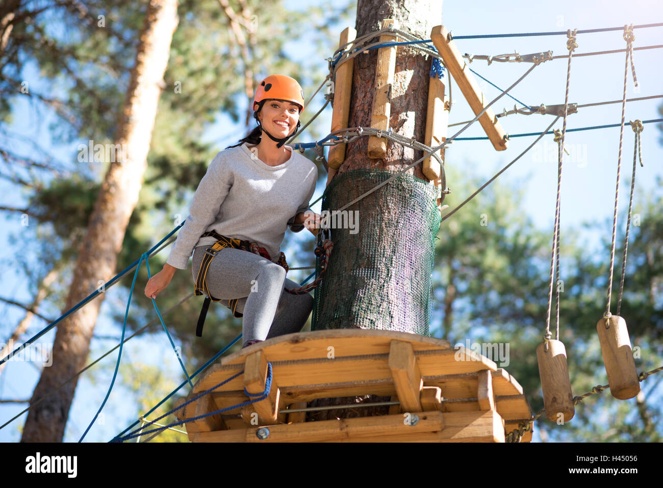 Delighted young woman squatting near the tree Stock Photo - Alamy