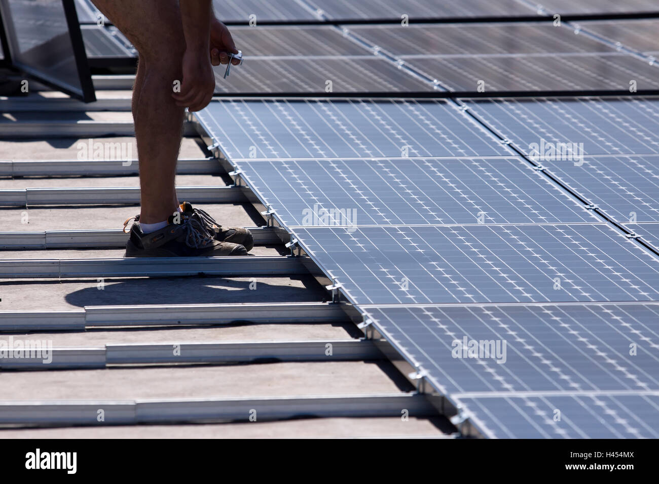 skilled worker fitting a photovoltaic panel on a roof Stock Photo - Alamy