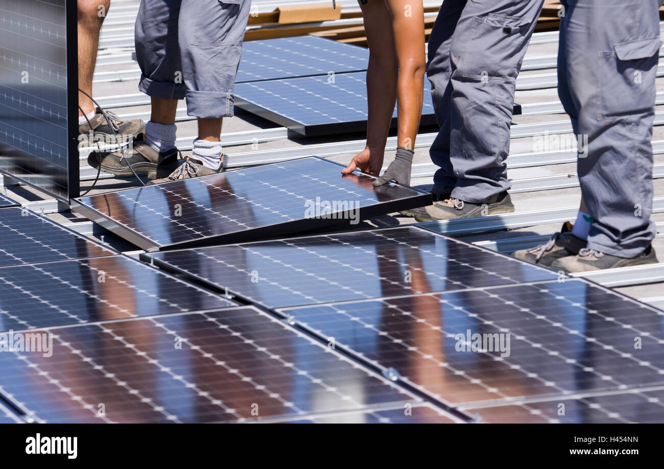 skilled worker fitting a photovoltaic panel on a roof Stock Photo - Alamy