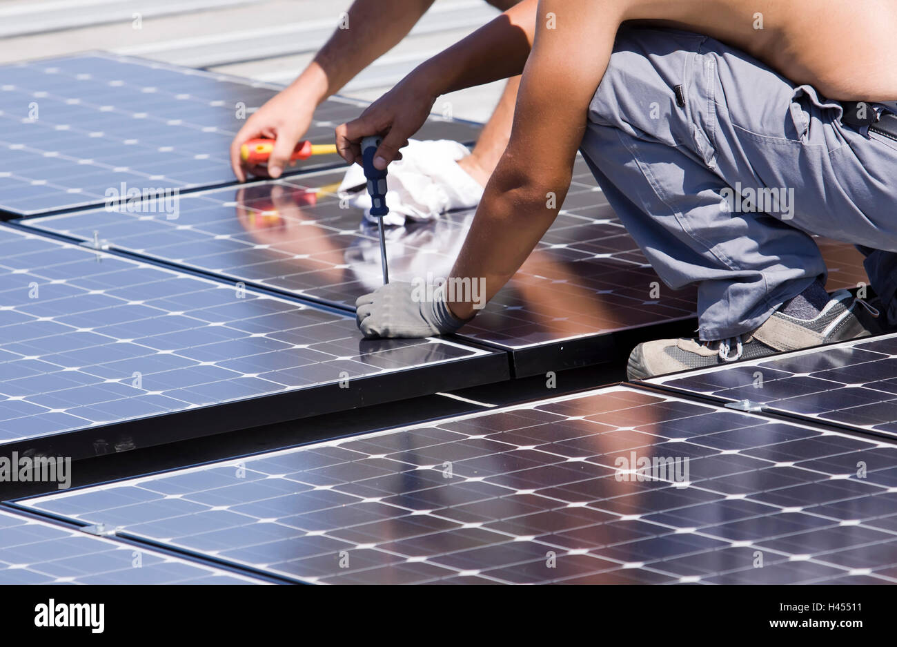 skilled worker fitting a photovoltaic panel on a roof Stock Photo - Alamy
