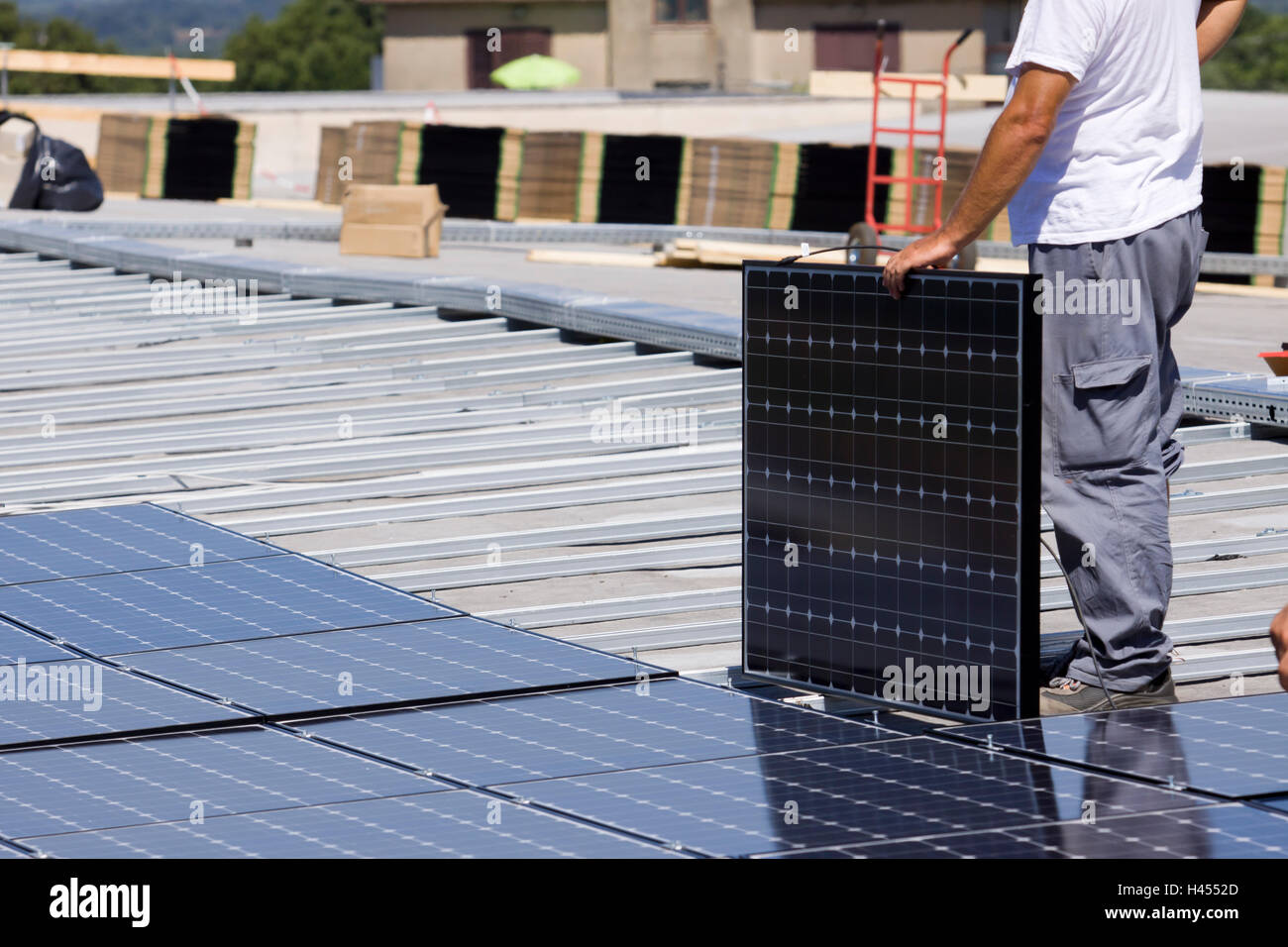 skilled worker fitting a photovoltaic panel on a roof Stock Photo - Alamy