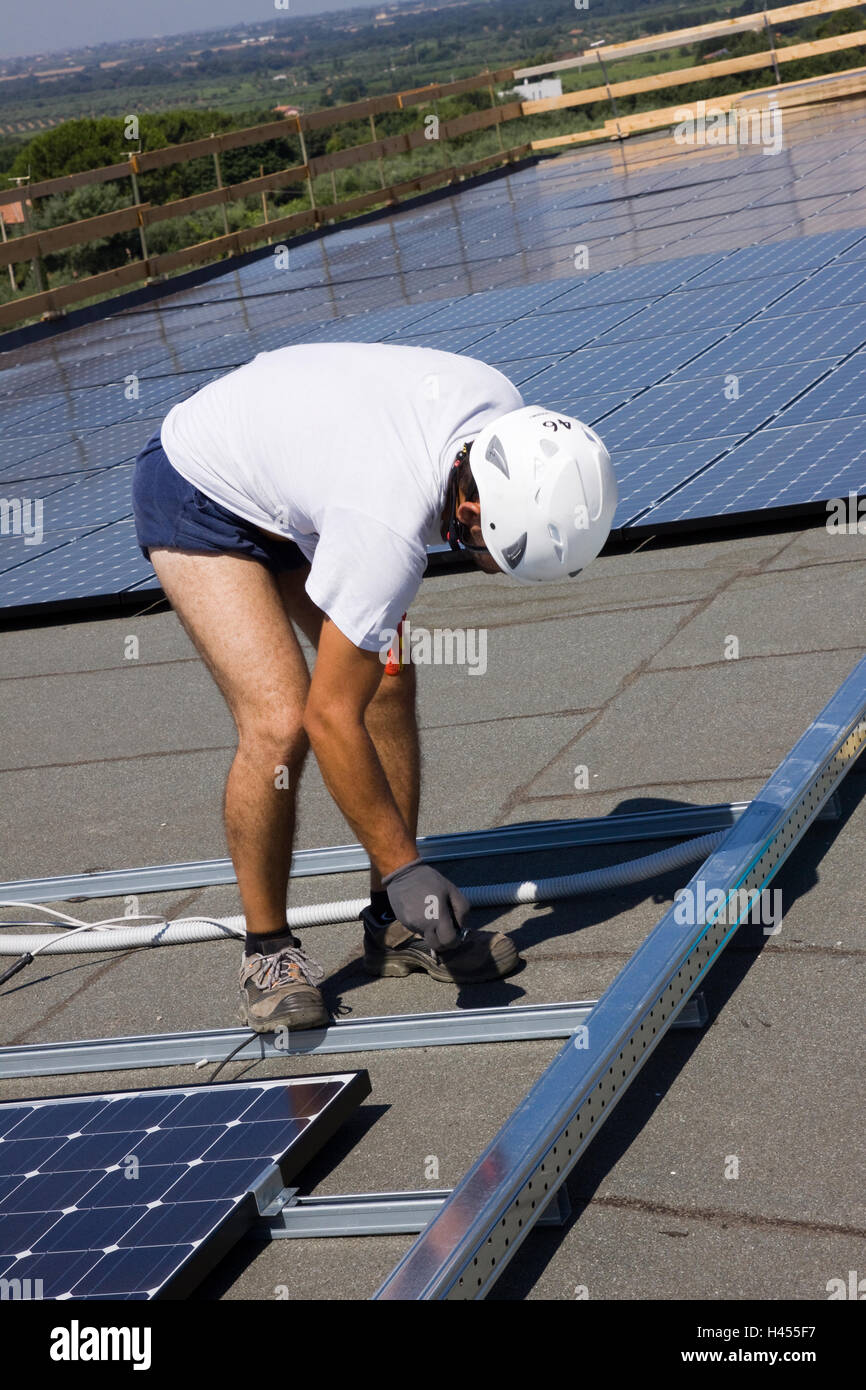 skilled worker fitting a photovoltaic plant on a roof Stock Photo - Alamy