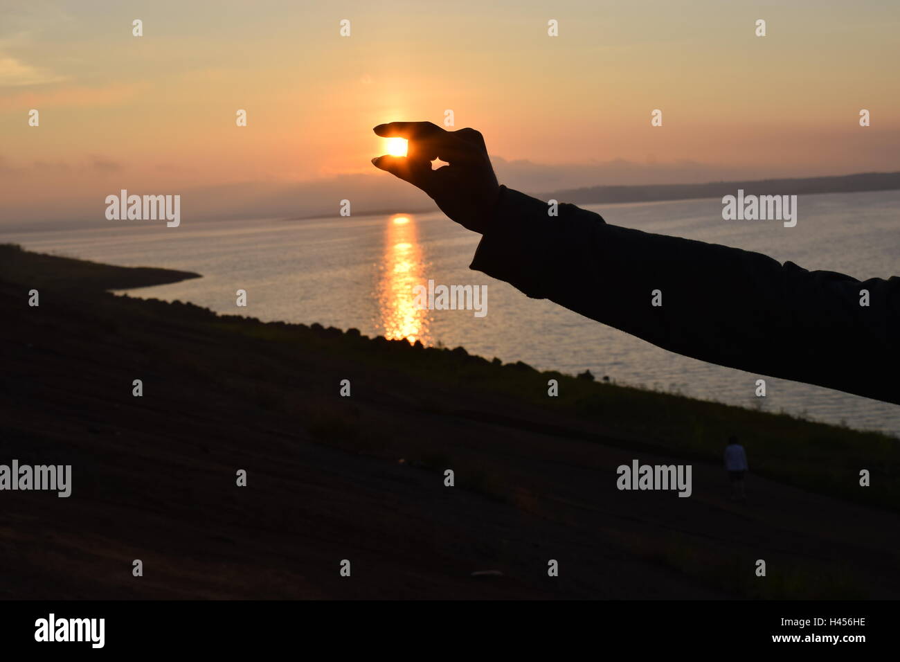 silhouette hand capture the sun in sunset Stock Photo - Alamy