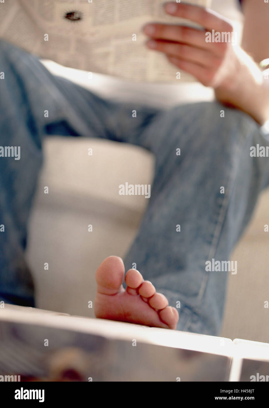 Reading man with foot on table, detail, blur Stock Photo - Alamy