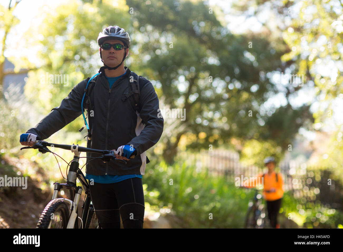 Male biker standing with mountain bike Stock Photo - Alamy