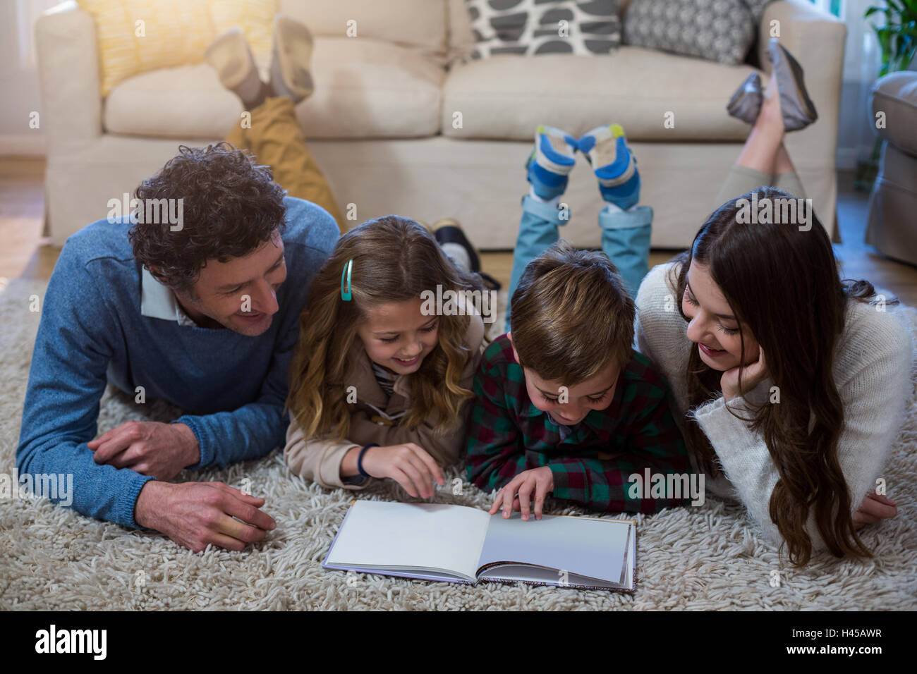 Family reading a book Stock Photo - Alamy