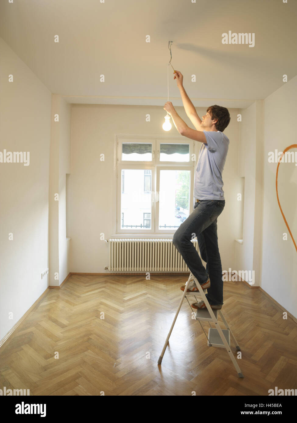 Room, man, young, light bulb, installs, ladder Stock Photo - Alamy