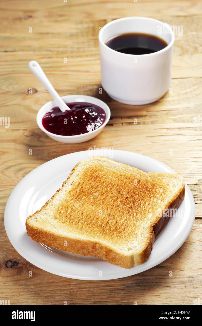 Roasted toast bread with raspberry jam and cup of coffee on old wooden ...