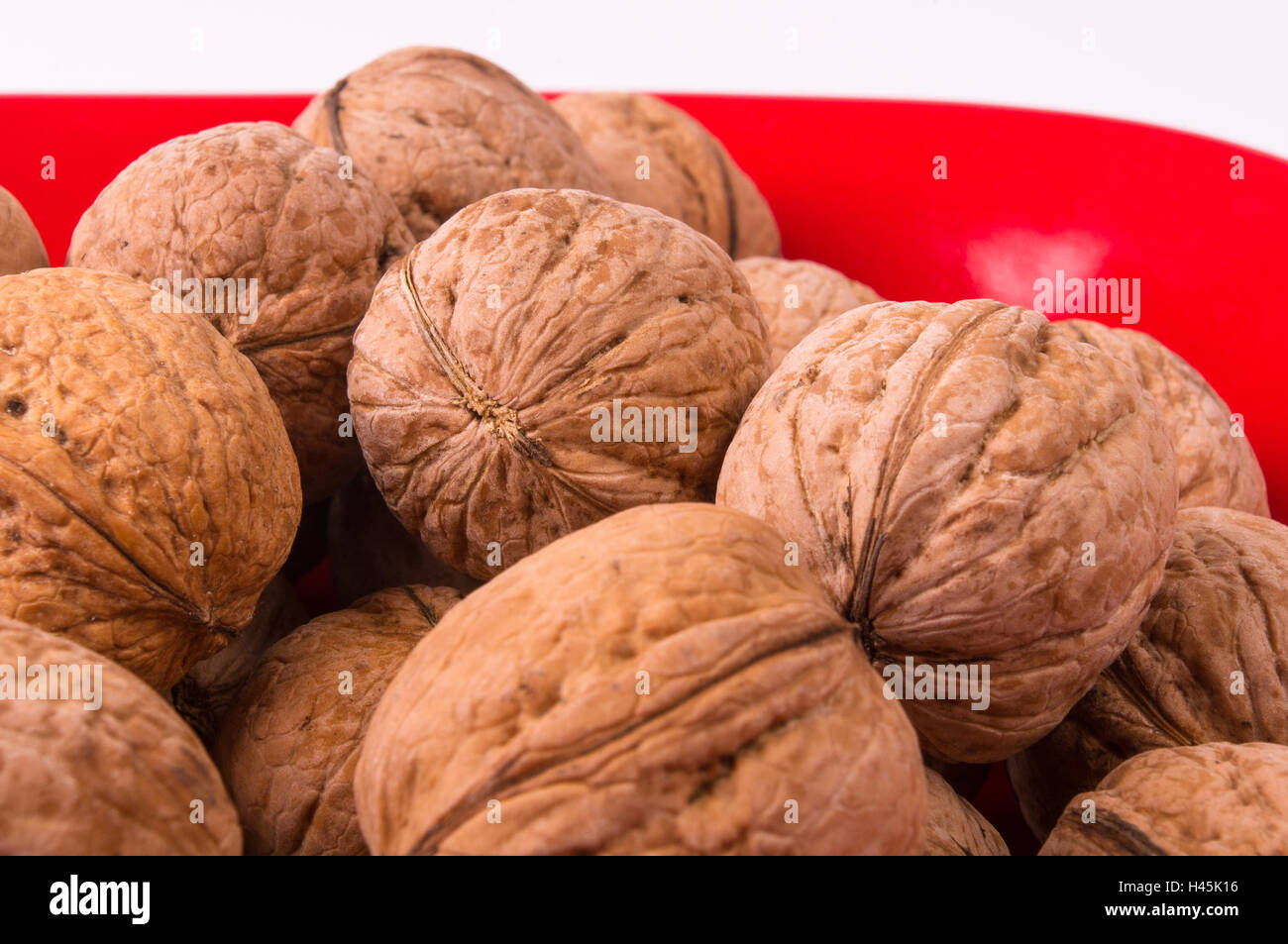 walnuts in red plate on white background Stock Photo - Alamy
