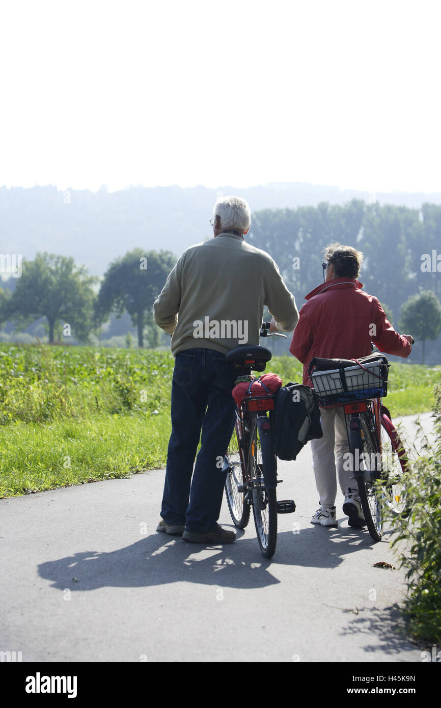 Senior couple, back view, bicycles, push, break, Weser mountainous ...