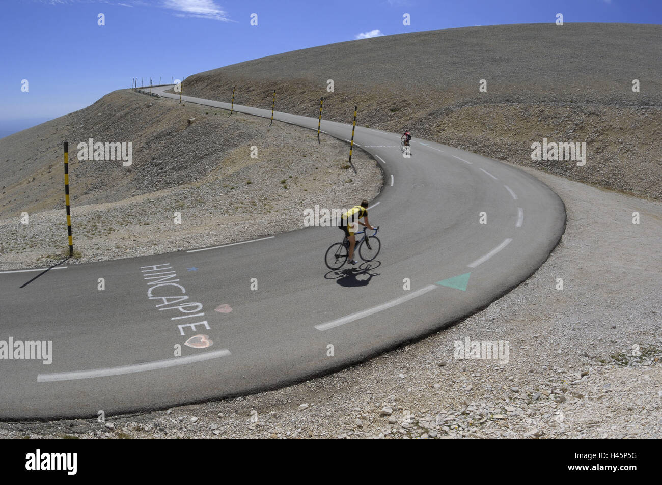 Mountain road, cyclist, back view, the sun, back light Stock Photo - Alamy