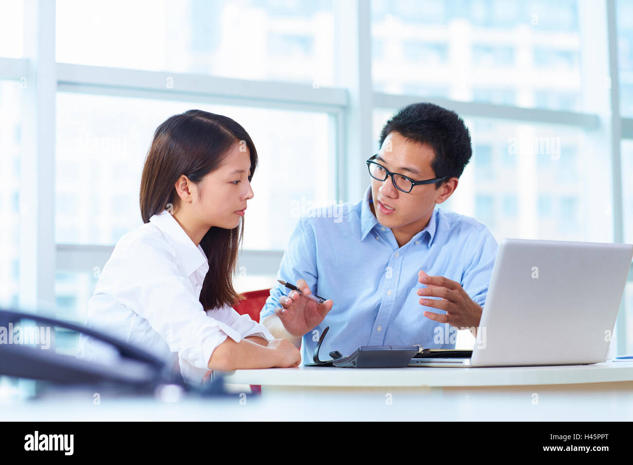 Two Young Asian business people in the Office Stock Photo - Alamy
