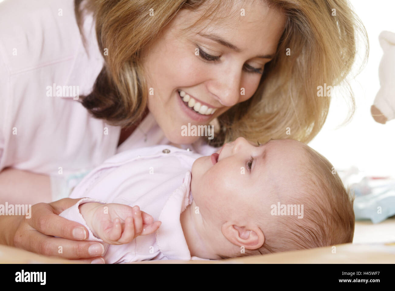 Woman, cuddle young, baby, children's room Stock Photo - Alamy