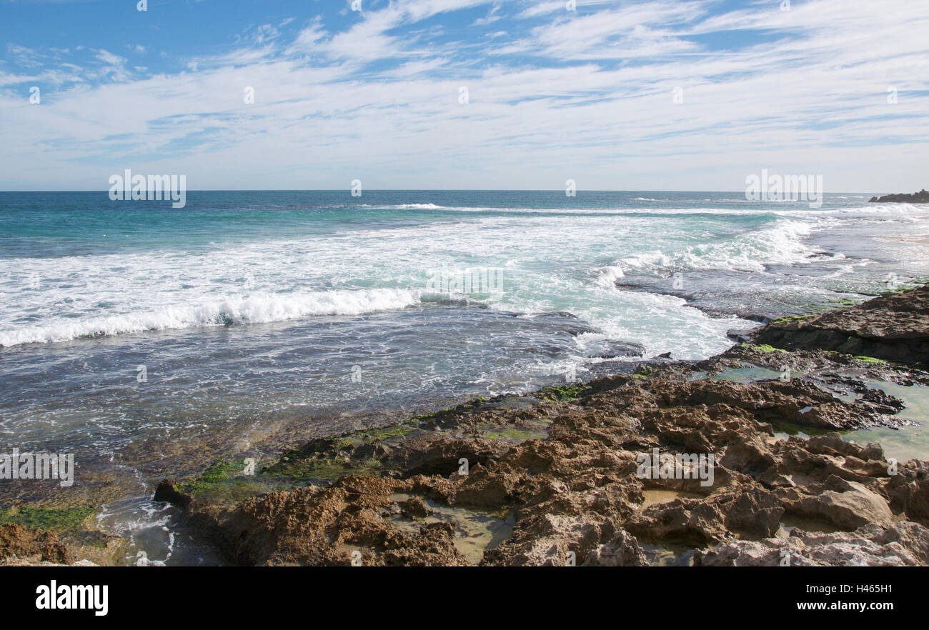 Indian Ocean waters rushing the limestone rock pools on remote beach at ...
