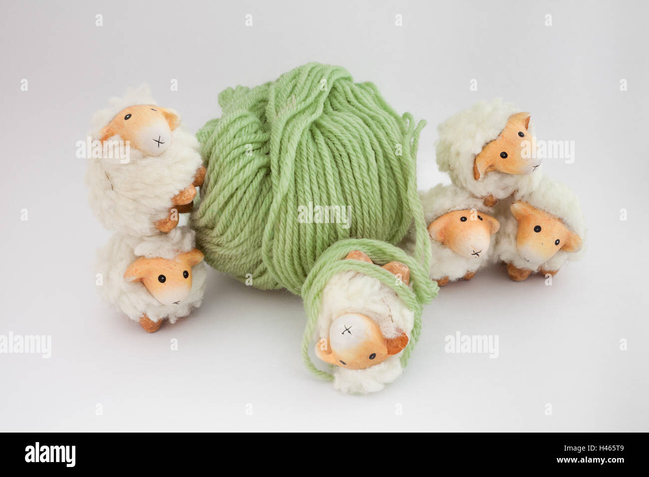 Cute sheep playing together with a ball of green wool Stock Photo - Alamy