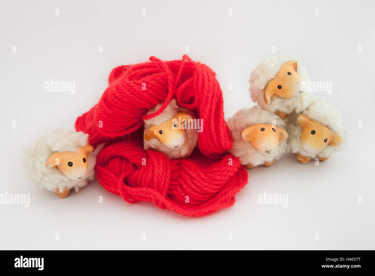 Cute sheep playing together with a ball of red wool Stock Photo - Alamy