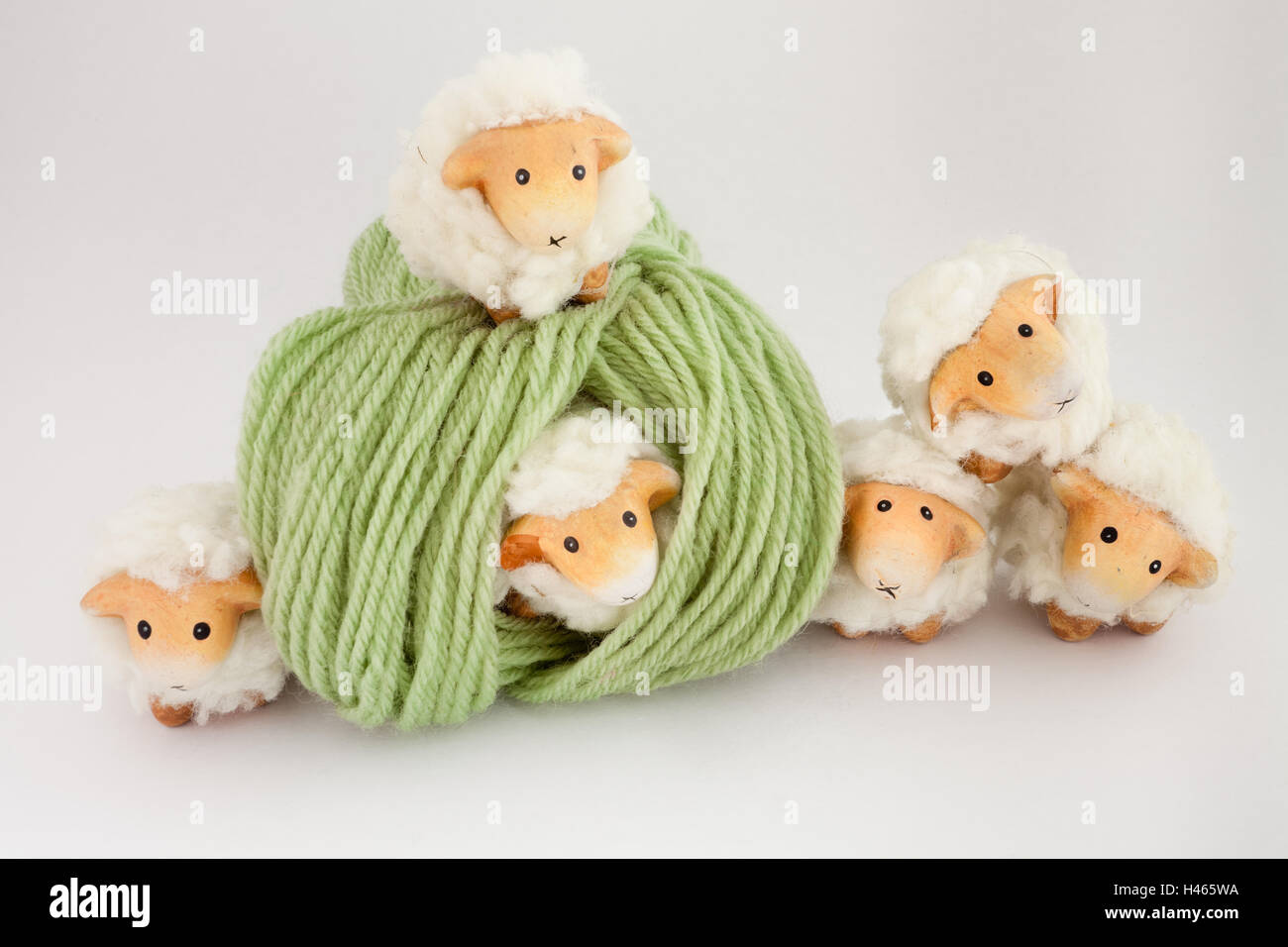 Cute sheep playing together with a ball of green wool Stock Photo - Alamy