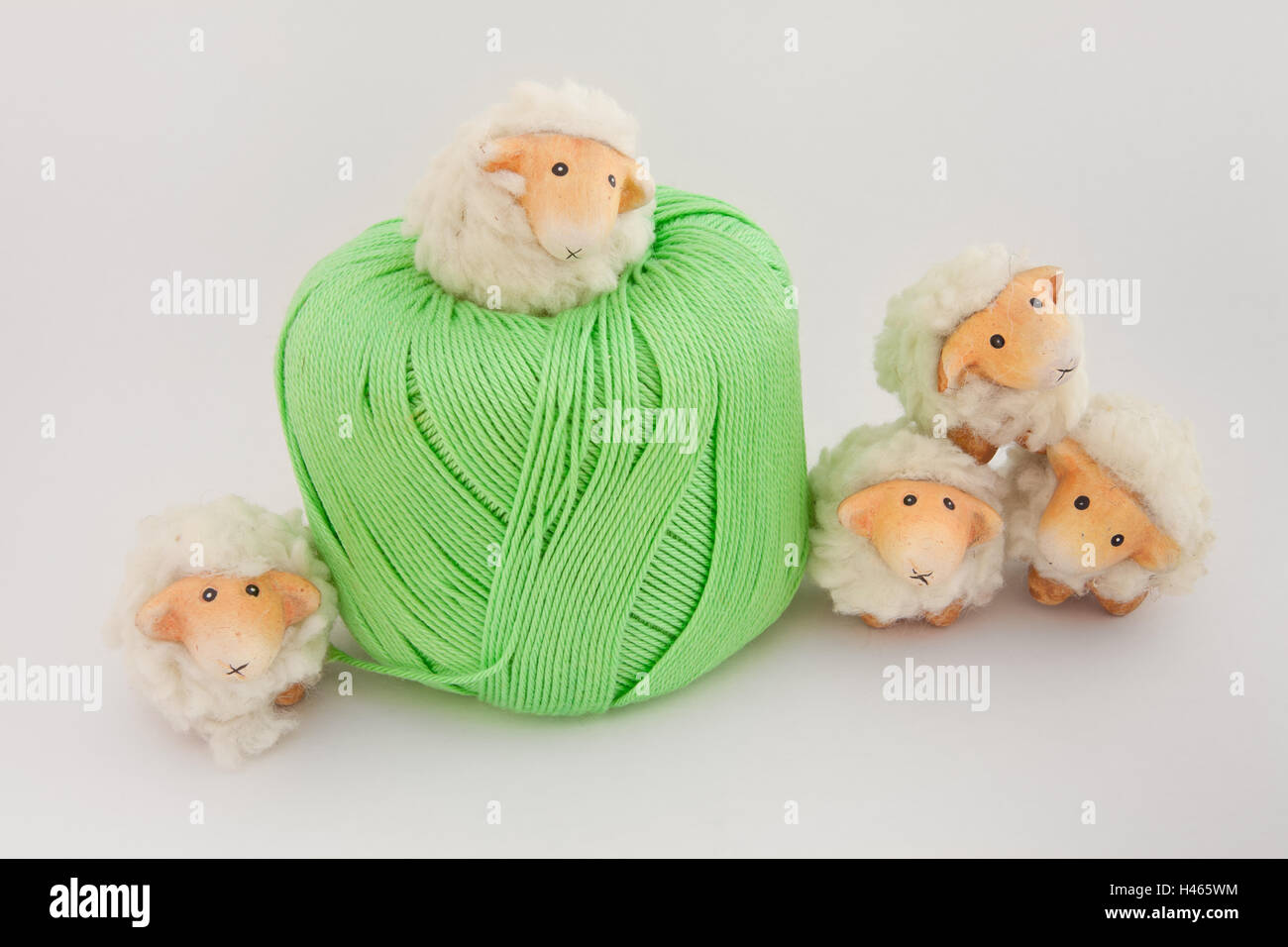 Cute sheep playing together with a ball of green wool Stock Photo - Alamy