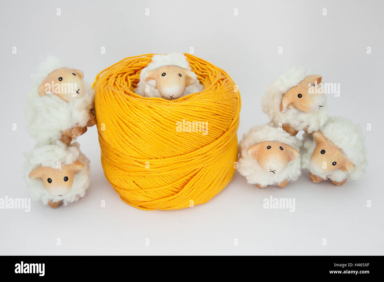 Cute sheep playing together with a ball of yellow wool Stock Photo - Alamy
