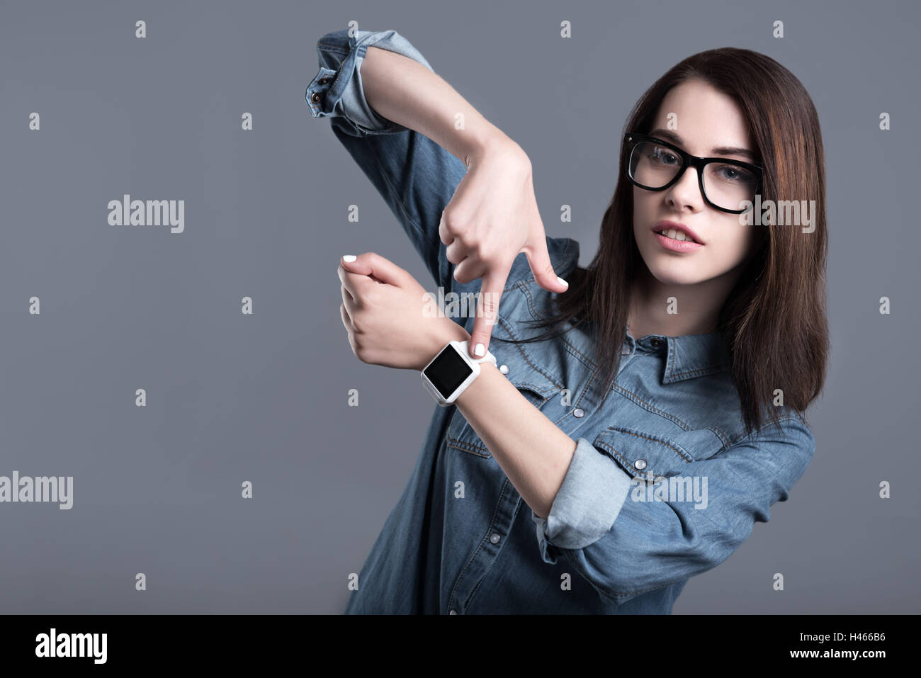 Young woman wearing smartwatch and pointing Stock Photo - Alamy