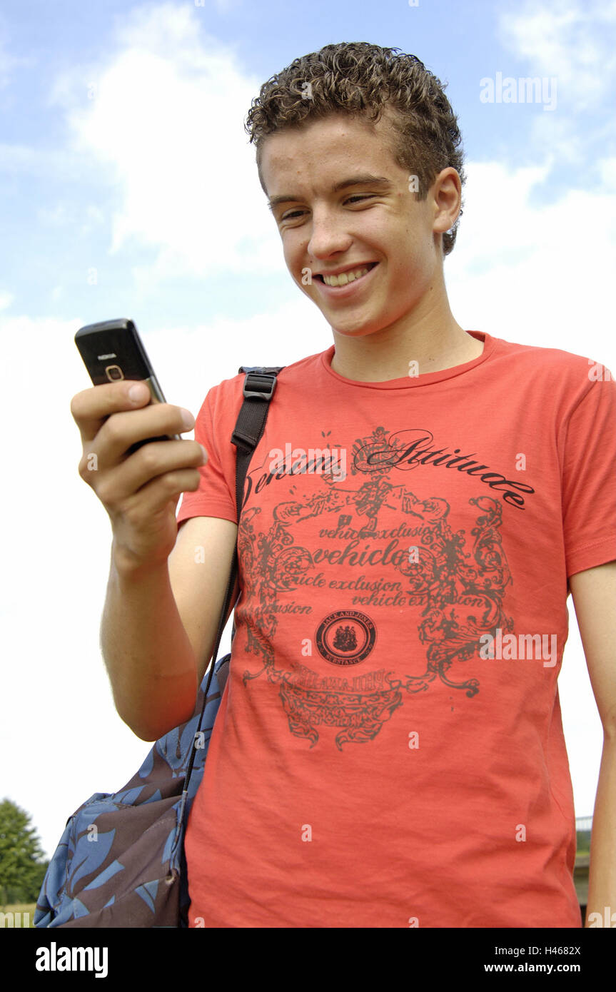 Teenager, boy, mobile phone, outside, half portrait Stock Photo - Alamy