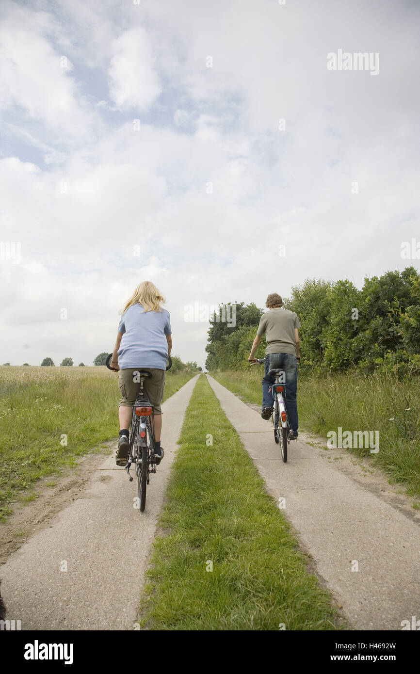 Boys, teenagers, two, bicycle driving, back view, way Stock Photo - Alamy