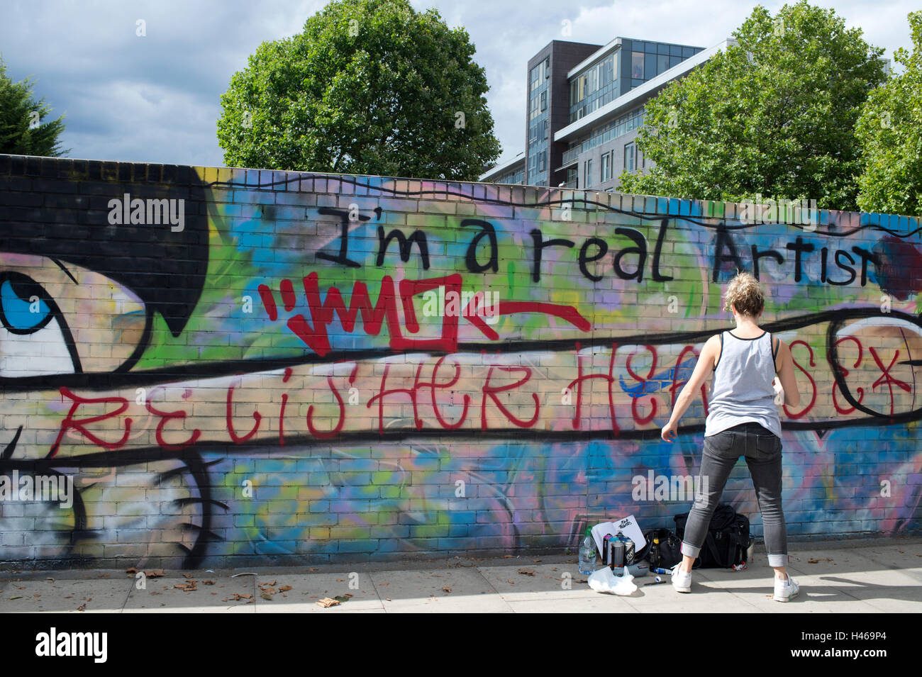 Hackney Wick. Woman painting on a wall - anti gentrification Stock ...