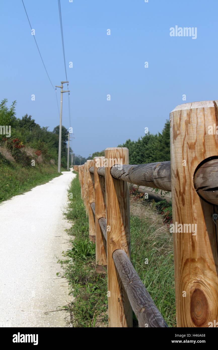 Dirt road for bike, in the summer. With parapet side built of wood ...