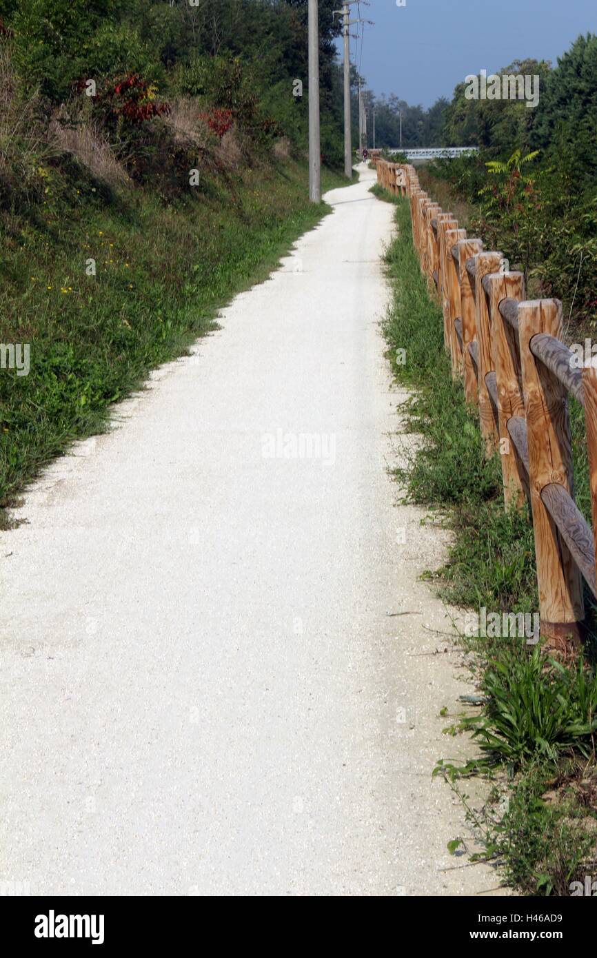 Dirt road for bike, in the summer. With parapet side built of wood ...