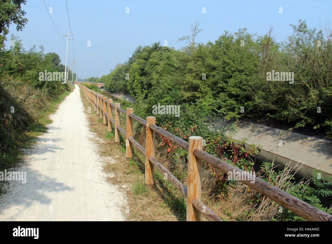 Dirt road for bike, in the summer. With parapet side built of wood ...
