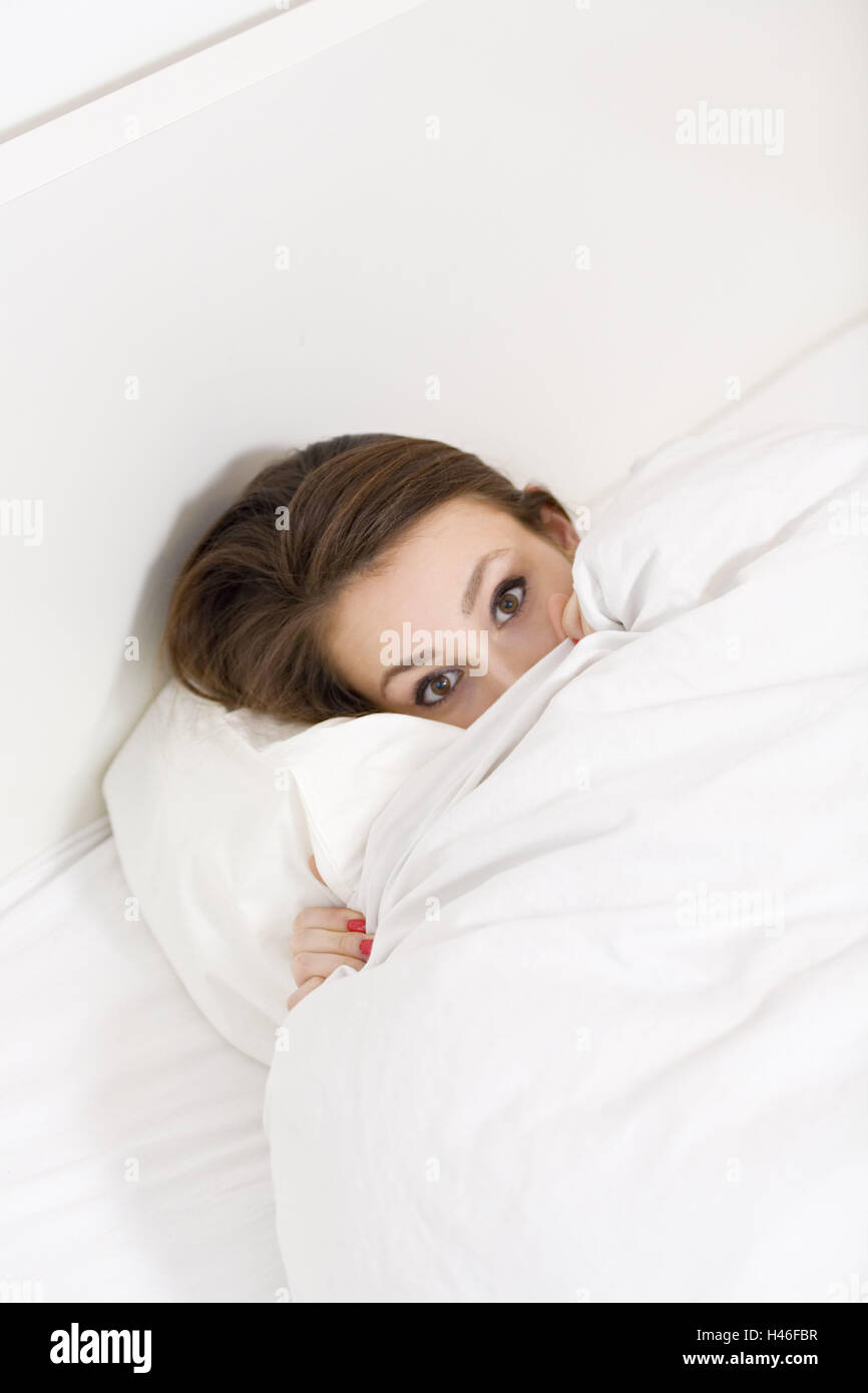 young woman looks under blanket out Stock Photo - Alamy