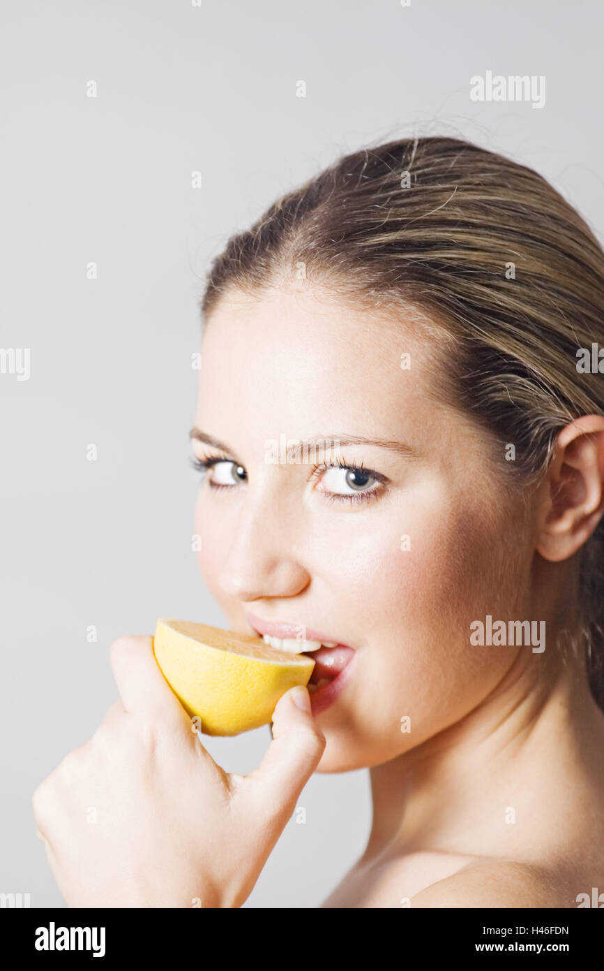 Woman bites in lemon, portrait Stock Photo - Alamy