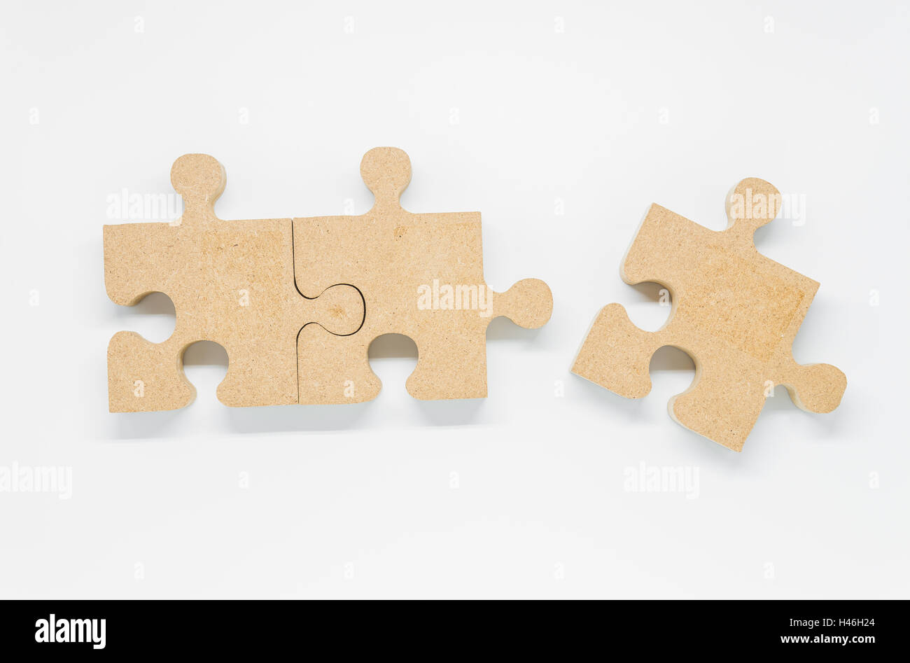 Three pieces of wooden puzzle on white background Stock Photo - Alamy