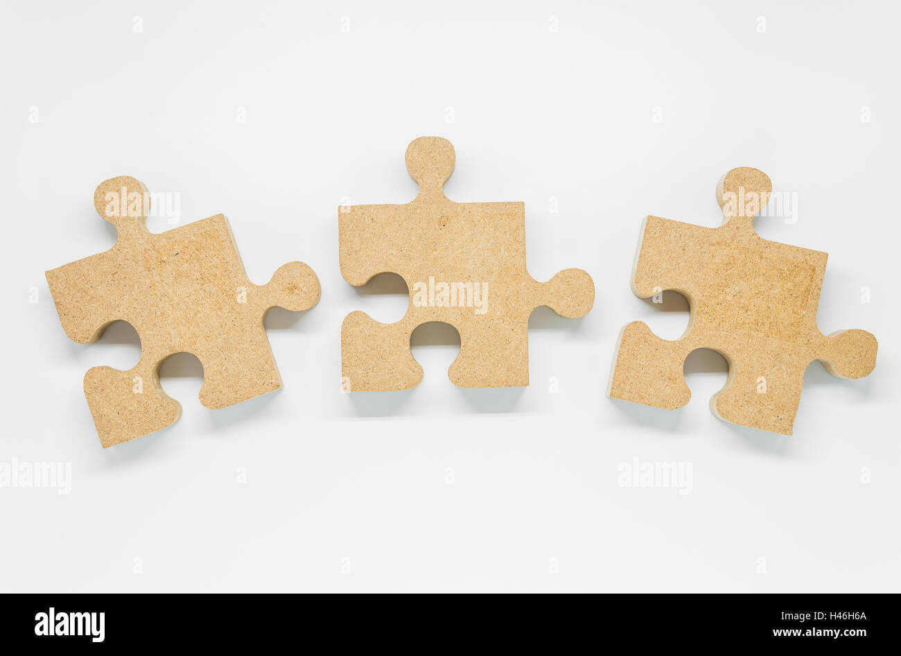 Three pieces of wooden puzzle on white background Stock Photo - Alamy