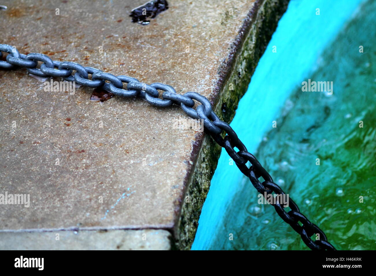 Metal chain on cyan blue pool board Stock Photo - Alamy