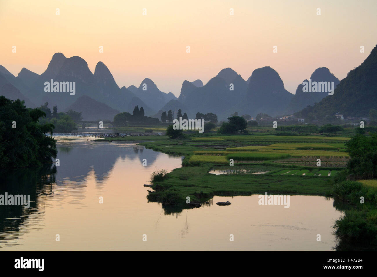 China, Yulong river with two-pronged mattock mountains, dusk Stock ...