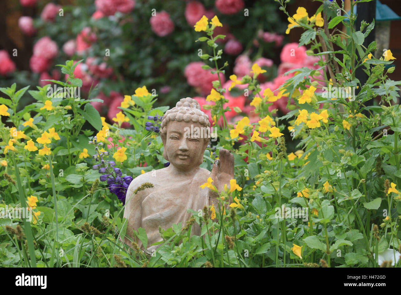 Garden figure between flowers Stock Photo - Alamy