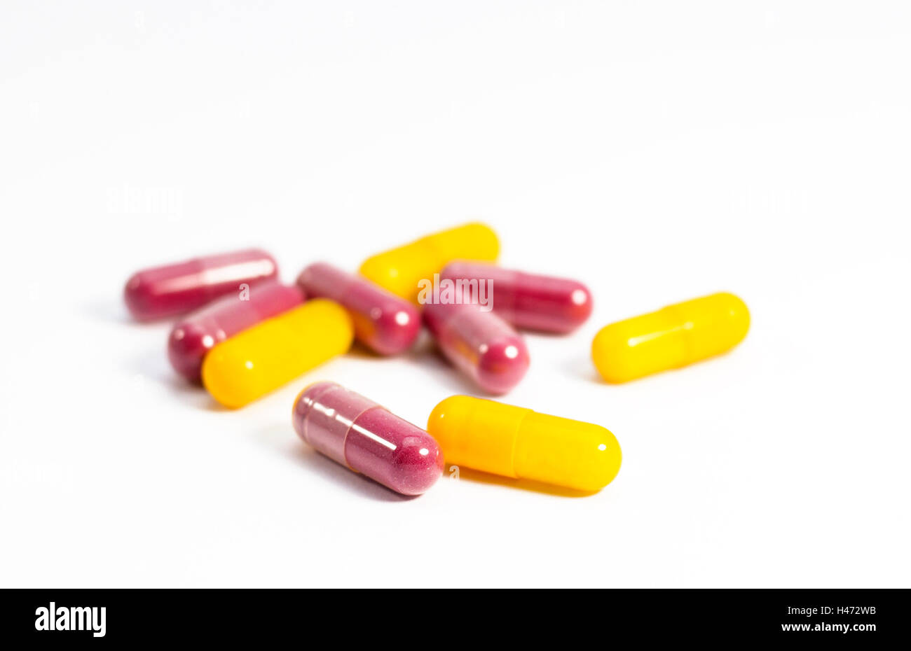 Red and yellow capsules with white background Stock Photo - Alamy