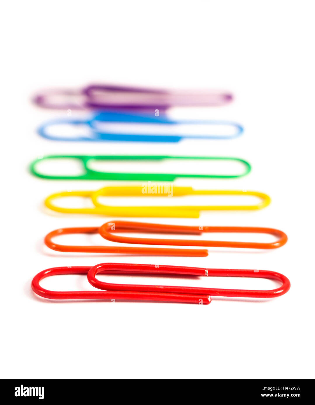 Some colored paper clips on white background Stock Photo - Alamy