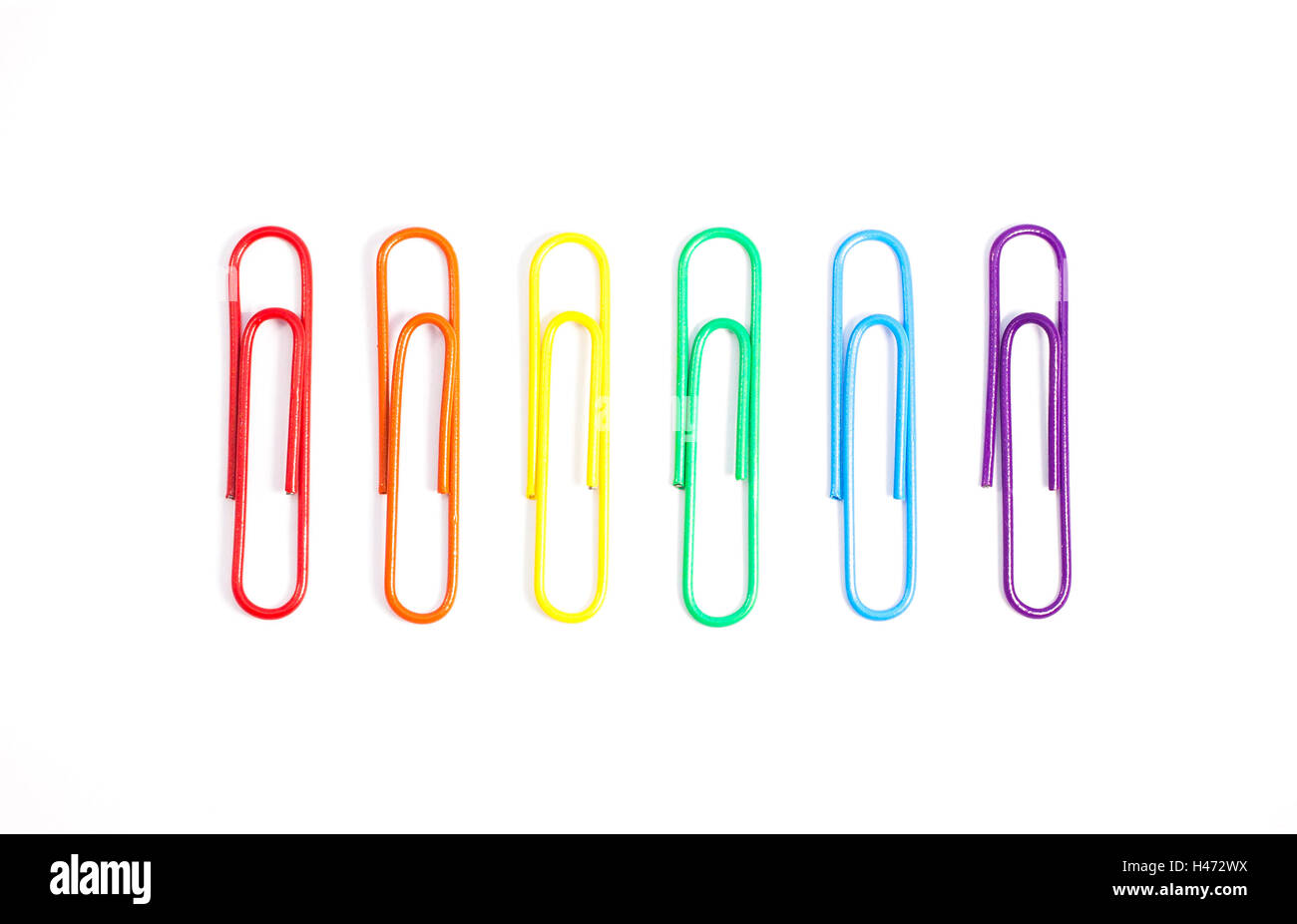 Some colored paper clips on white background Stock Photo - Alamy