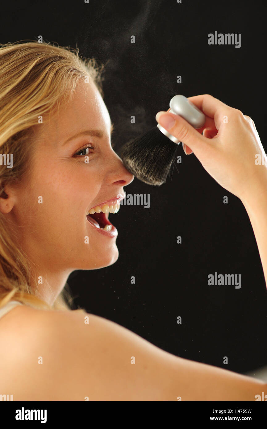 Blond woman powders her nose Stock Photo - Alamy