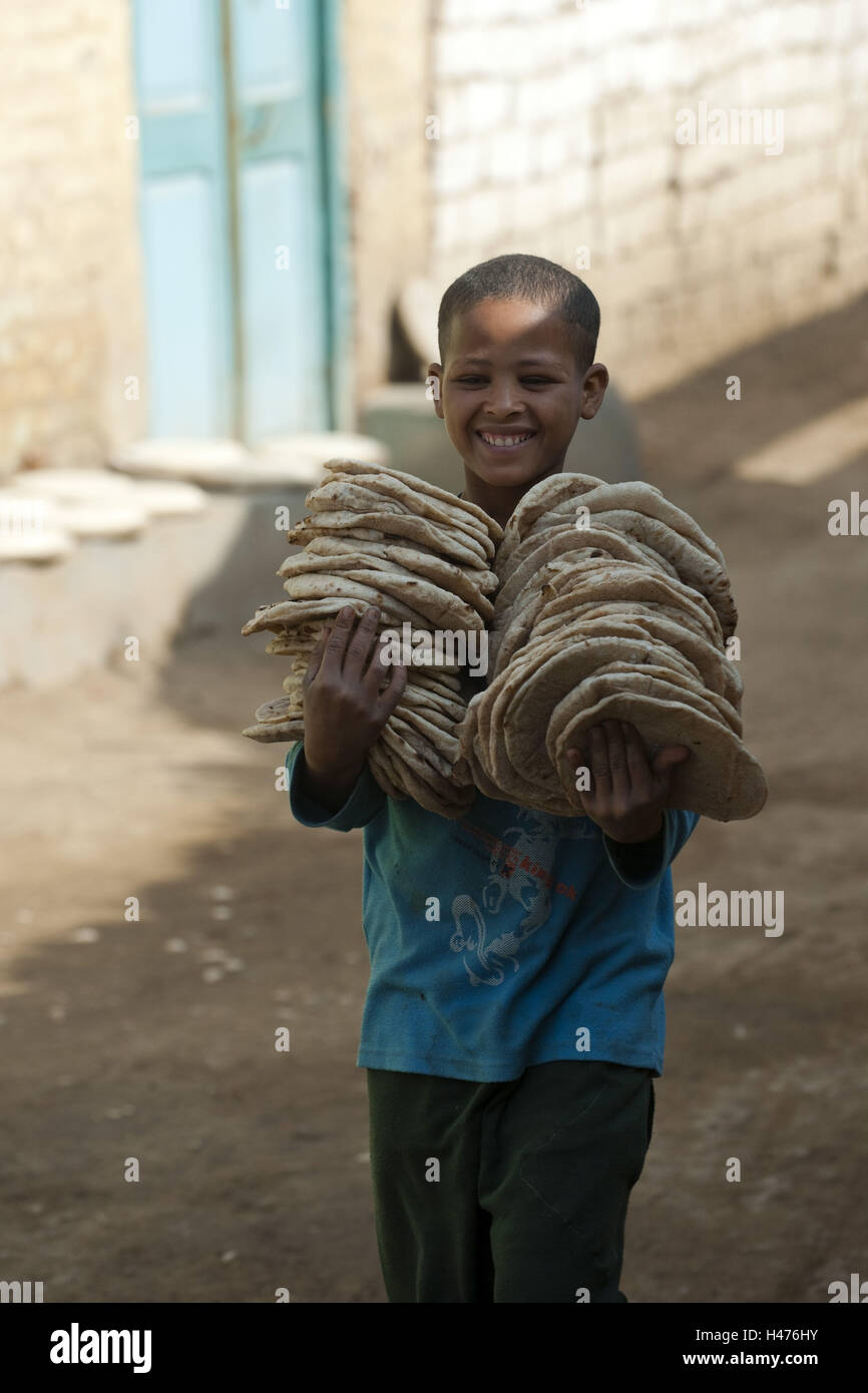 Egypt, boy with bread in the Coptic village Garagos to the north Luxor ...
