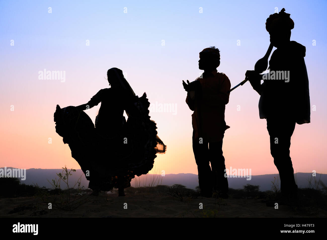 Sunset, silhouette of a gypsy woman dancing a traditional dance with ...