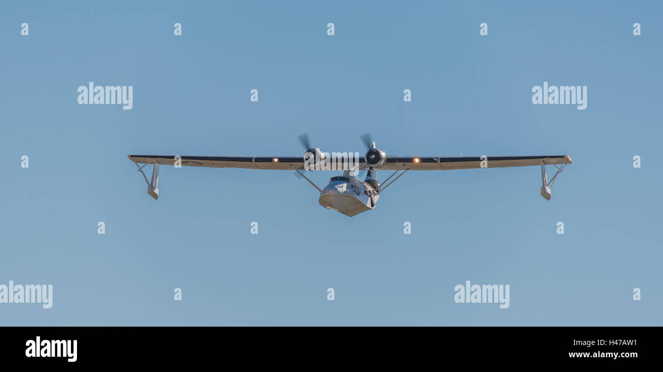 A Catalina seaplane catches the light as it turns, wingtip floats ...